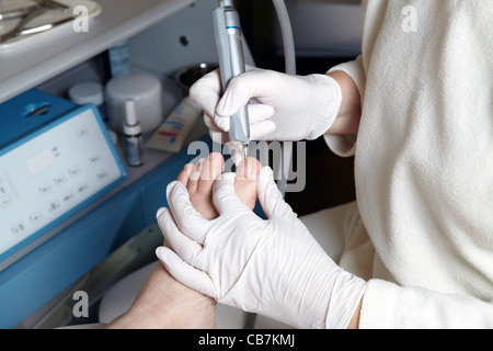A podiatrist edit the toenails with a grinding machine Stock Photo - Alamy