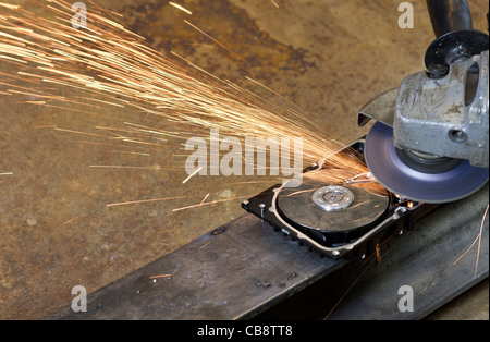 hard disk drive with rotating grinder and sparks in front of rusty back ...