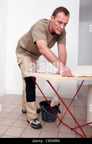 Man gluing paper together Stock Photo - Alamy