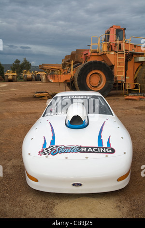 A sleek and streamlined drag racing car approaches the start line at ...