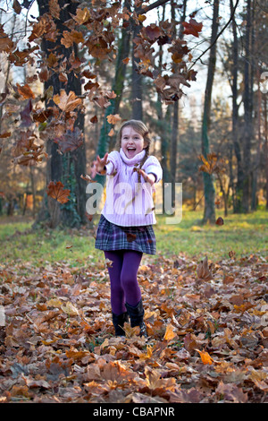 girl catching leaves in autumn Stock Photo - Alamy
