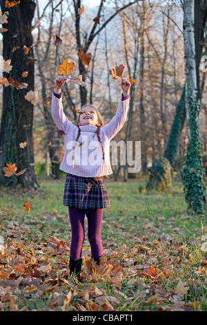 girl catching leaves in autumn Stock Photo - Alamy