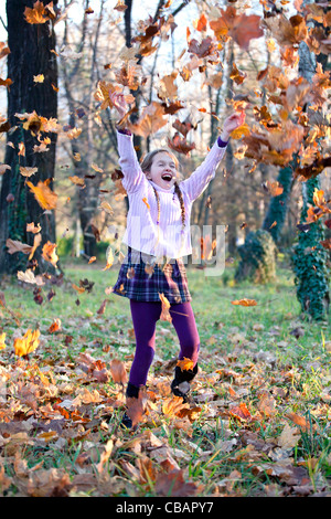 girl catching leaves in autumn Stock Photo - Alamy