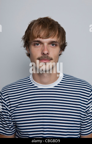 Young handsome man wearing striped t-shirt standing over pink isolated ...