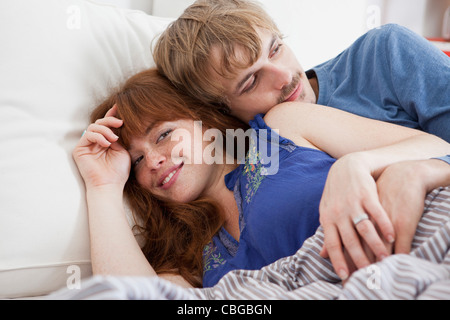 Portrait of a couple snuggling in bed Stock Photo - Alamy