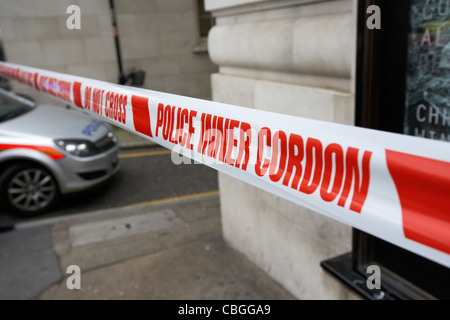 Police inner cordon tape barrier and a scene of crime officer ...
