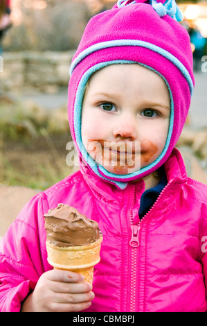 Girl with ice cream cone in front of hedge Stock Photo - Alamy