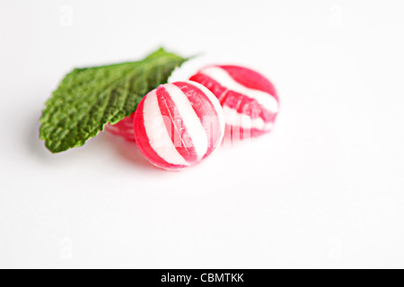 Three red and white striped sweetie bags, each overfloweing with ...