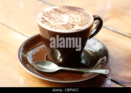 cup of cappuccino and cup of coffee on a wooden table Stock Photo - Alamy