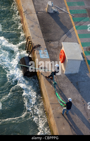Men securing ships' hawser ropes to bollards on dockside Stock Photo ...