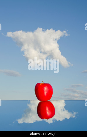 red apple on mirror and sky background with clouds Stock Photo - Alamy