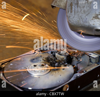 hard disk drive with rotating grinder and sparks in front of rusty back ...