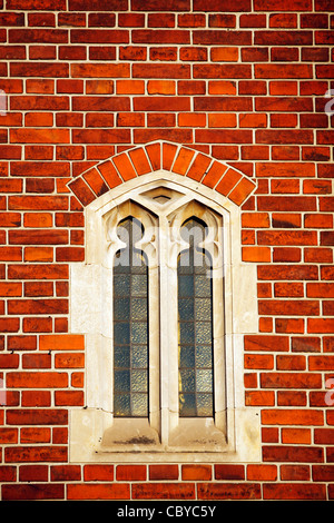 Close up of the façade of a brick wall with weathered yellow paint and ...