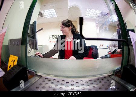 a woman bank teller at HSBC bank, UK Stock Photo - Alamy
