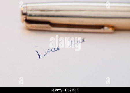 the words "Dear Sir" handwritten in ink with fountain pen in background ...