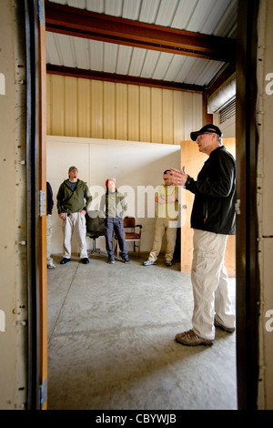 A team of law enforcement agents are instructed in methods for entering ...