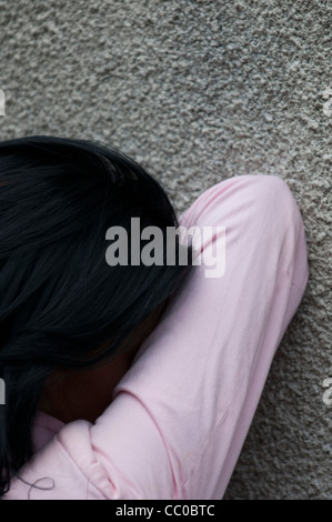Depressed woman crying alone leaning on a wall at home Stock Photo - Alamy
