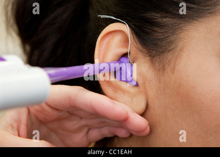 Injecting compound into the ear to create a hearing aid mould Stock ...