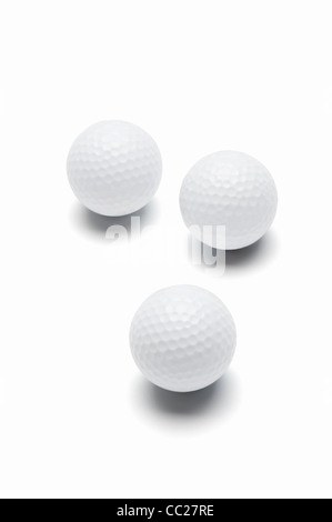 Three golf balls close up on a green red and blue tees. Cut out on a ...