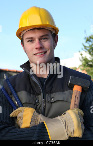 young builder holding chisel and hammer Stock Photo - Alamy