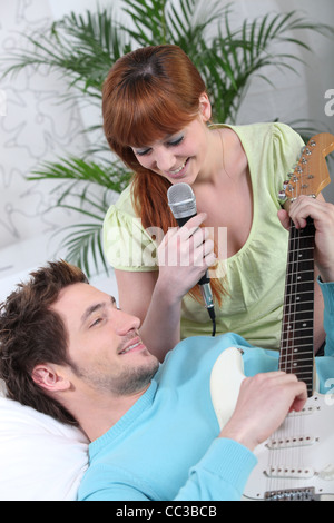 Serenading him with a song. a young woman playing guitar for her ...