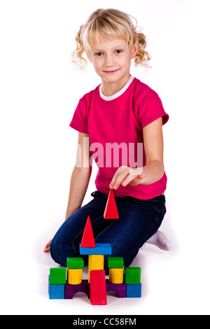 Beautiful girl building a castle with cubes isolated on white Stock ...