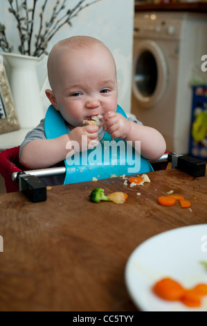 Baby Boy feeding himself Stock Photo - Alamy