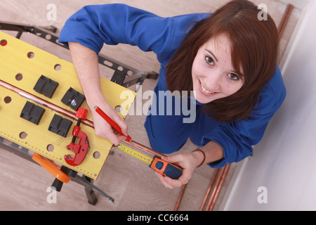 Woman measuring copper pipe Stock Photo - Alamy