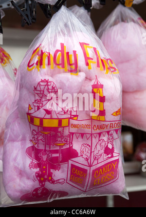 Bags of candy floss on sale at a fairground stall and hanging against a ...