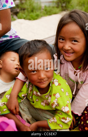 joyful boy looking at camera while asian classmate writing on blurred ...