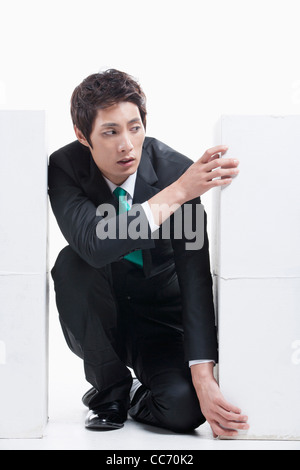 A man stuck between the piled boxes Stock Photo - Alamy