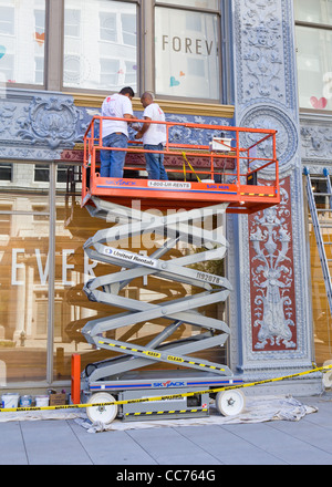 Men on a scissor lift working in a building Stock Photo - Alamy