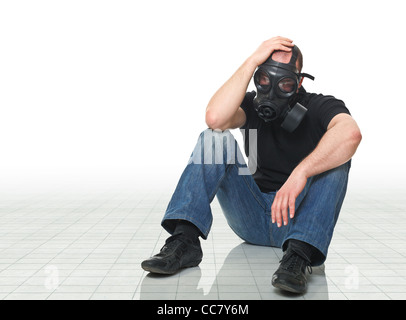 Portrait of a sad man with gas mask holding dried flowerpot on the grey ...