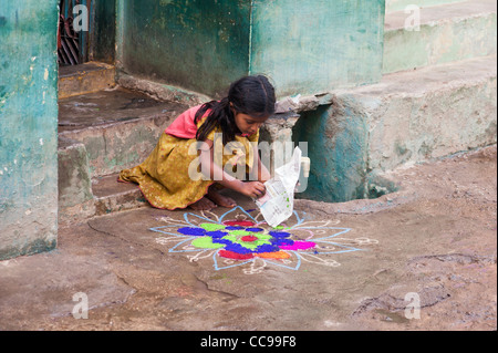Indian child making rangoli in front of home during festival season ...