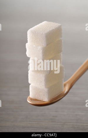 Stack of six sugar cubes on fabric, white background. Daily recommended ...