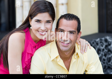 A Hispanic couple smiling at a camera with blurred background Stock ...