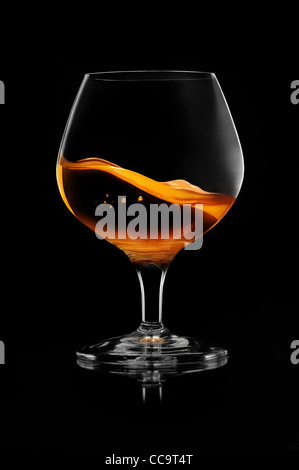 Splash of cognac in glass, isolated on white background Stock Photo - Alamy