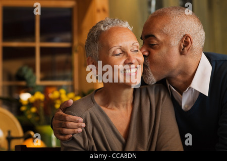 Older couple kissing in kitchen, wife kisses husband goodbye to start ...