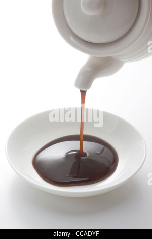 A vertical shot of sauce pouring on cheeseburger sandwich with fried ...