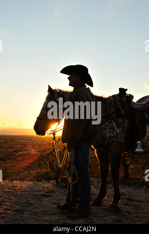 Riders and their horses take in the sunset in the Sonoran Desert ...