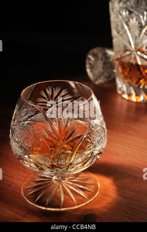 crystal brandy glass on the oak table with bottle Stock Photo - Alamy