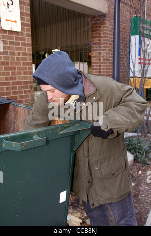 Homeless man looking into garbage dumpster Stock Photo - Alamy