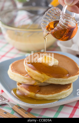 Selective focus shot of a person pouring milk in a green cup of coffee ...