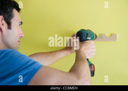 Yellow power drill and man using electric Jigsaw on the table with ...