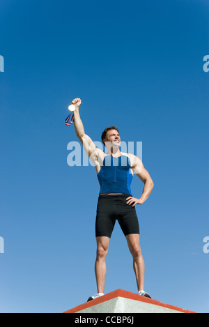 Man raising hand and holding gold medal. Concept of ambition ...