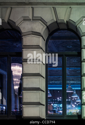 Night view on the ground floor of modern office building with big glass ...