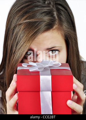 A woman holding a red gift box looks down in anticipation Stock Photo ...