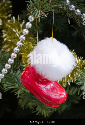 Christmas decoration with Santa's red boot, garland, beads closeup ...