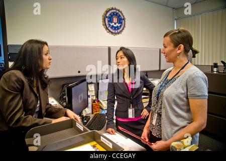 Three female FBI agents discuss a case in Santa Ana, CA, office. Note ...