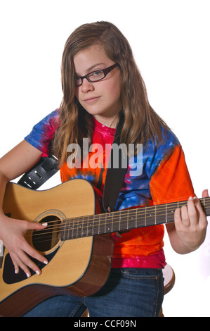 Girl on a stool playing an acoustic guitar isolated on white background ...